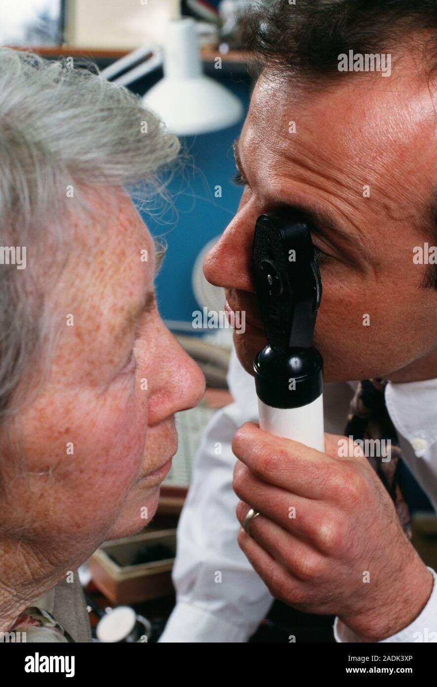 Eye examination. General practice (GP) doctor examining a woman's eye ...