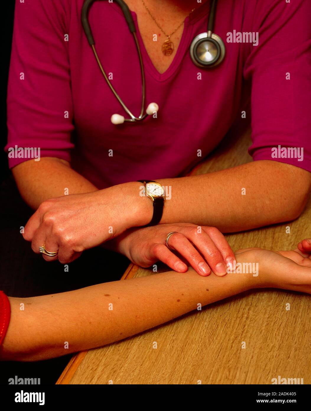 Pulse measurement. Patient having their pulse measured by a doctor. Her ...