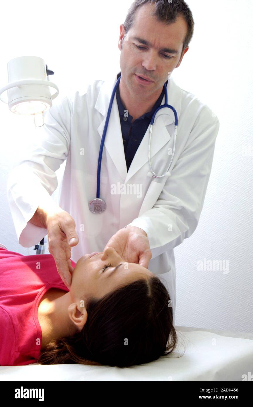 Neck gland examination. Doctor using his hands to palpate (feel) the ...