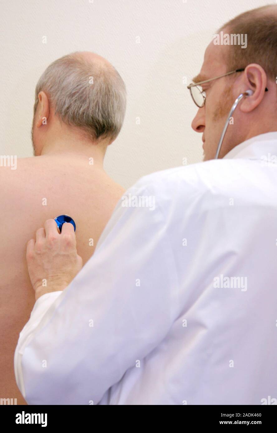 MODEL RELEASED. Chest examination. Doctor using a stethoscope to listen ...