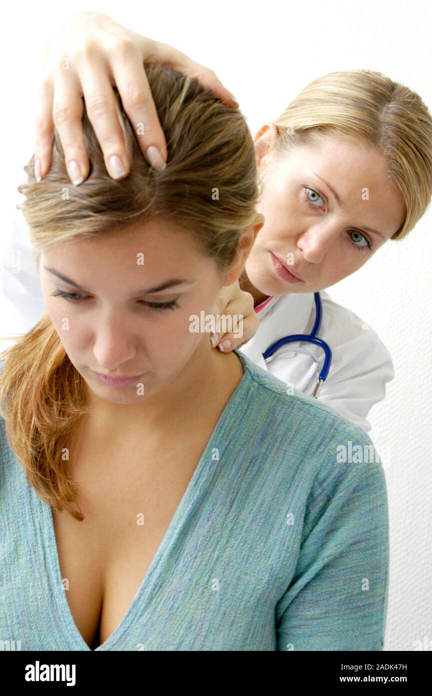 MODEL RELEASED. Neck examination. General practitioner palpating a ...