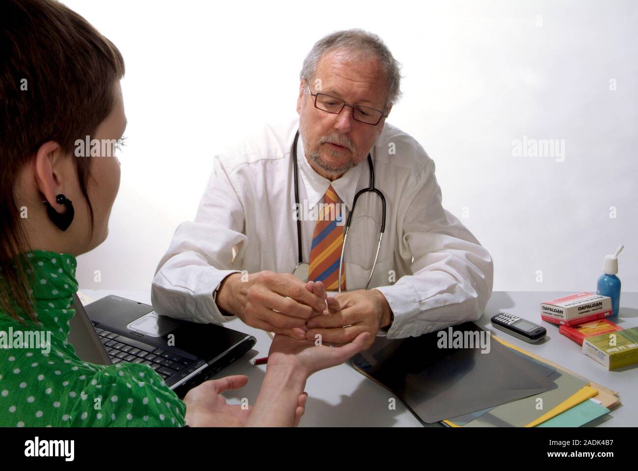 MODEL RELEASED. Finger joint examination. Doctor carrying out an ...