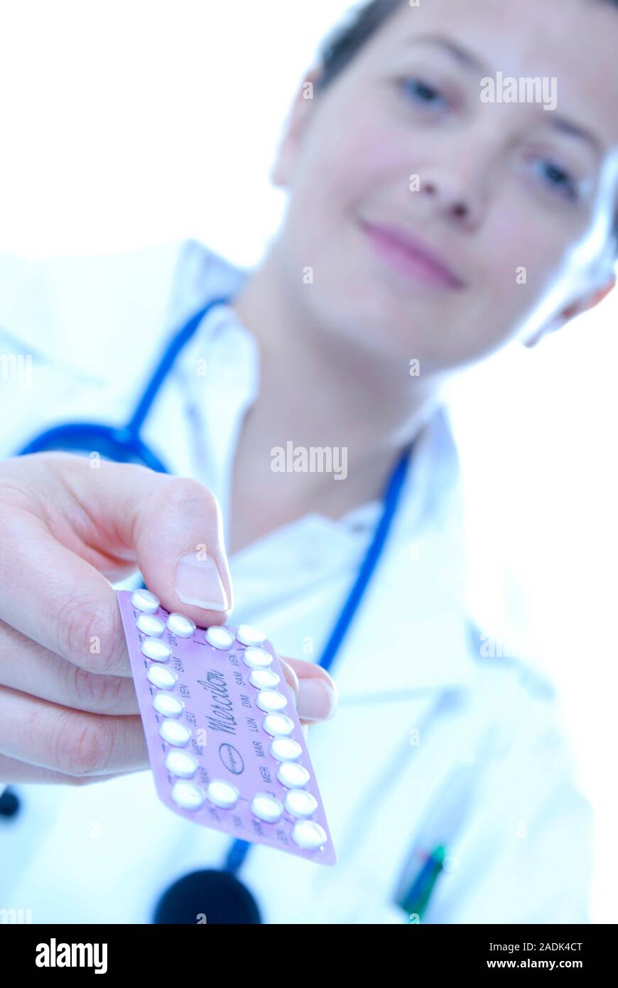 MODEL RELEASED. Family planning. Doctor passing over a packet of oral ...