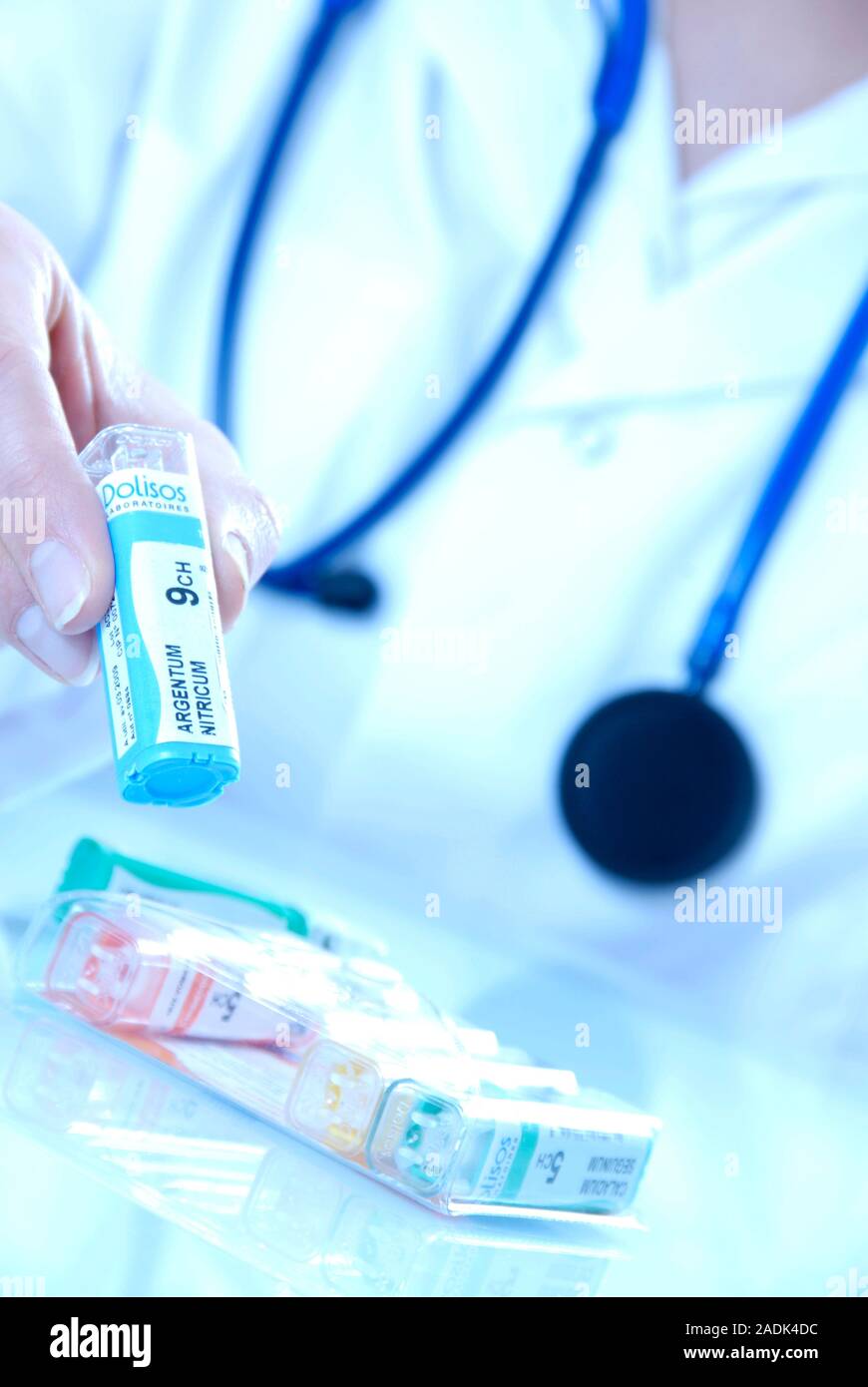 MODEL RELEASED. Homeopathic medicine. GP holding a dispenser containing ...