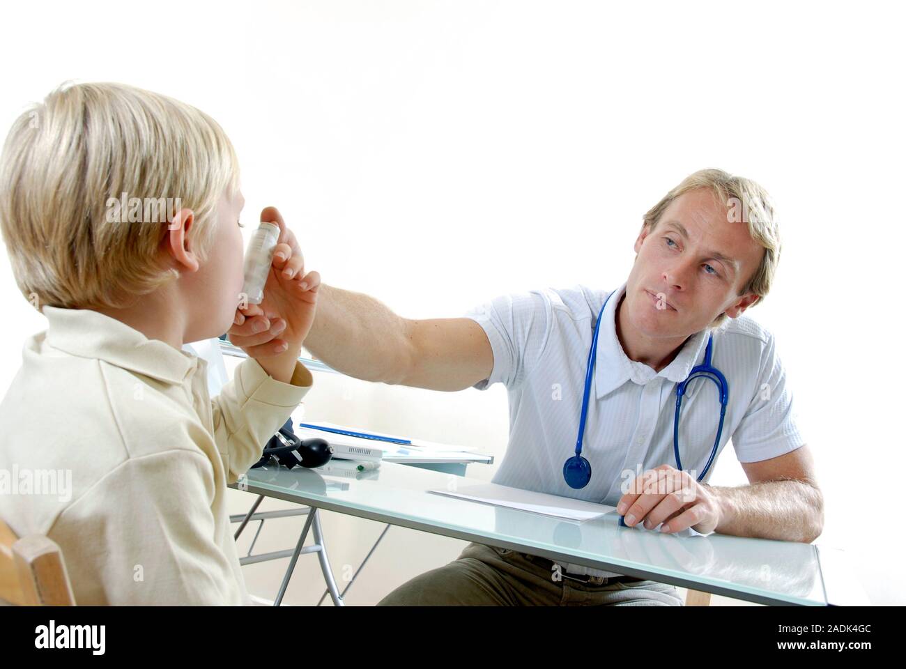 Inhaler demonstration. Doctor showing an asthmatic boy how to use an ...
