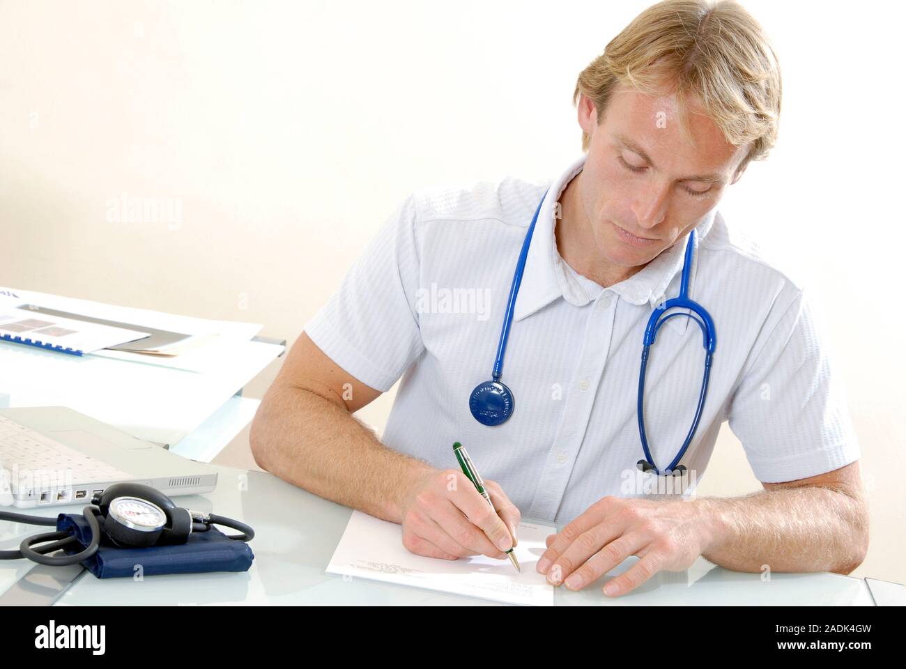 Doctor writing notes at his desk Stock Photo - Alamy