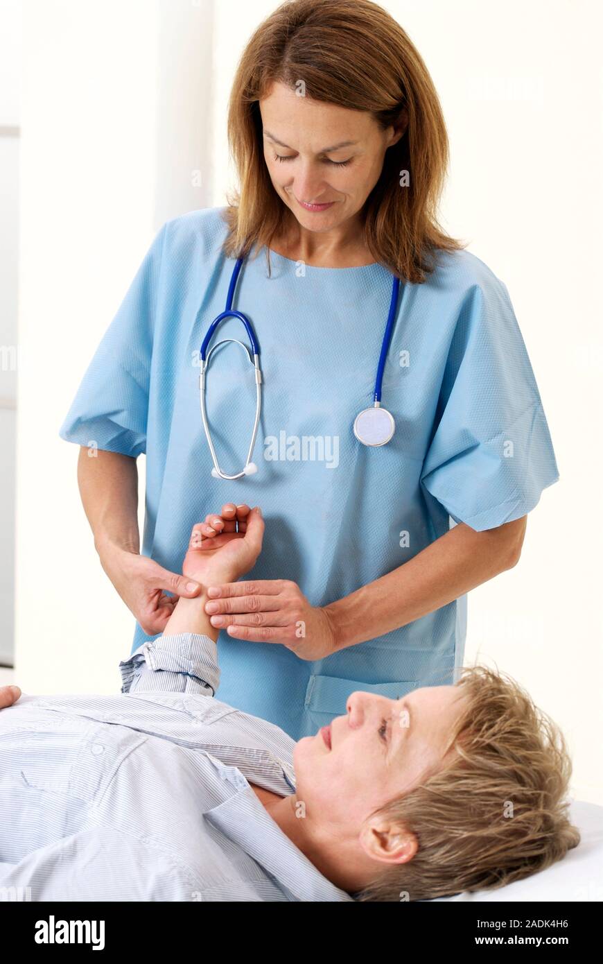 Wrist pulse. Patient having her wrist pulse measured by a doctor Stock ...