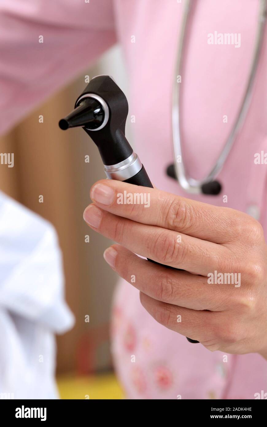 Otoscope. Ear nose and throat (ENT) consultant holding an otoscope, an ...