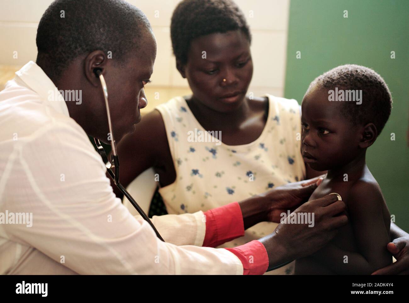 MODEL RELEASED. Assessing a sick child. Doctor listening to a young ...