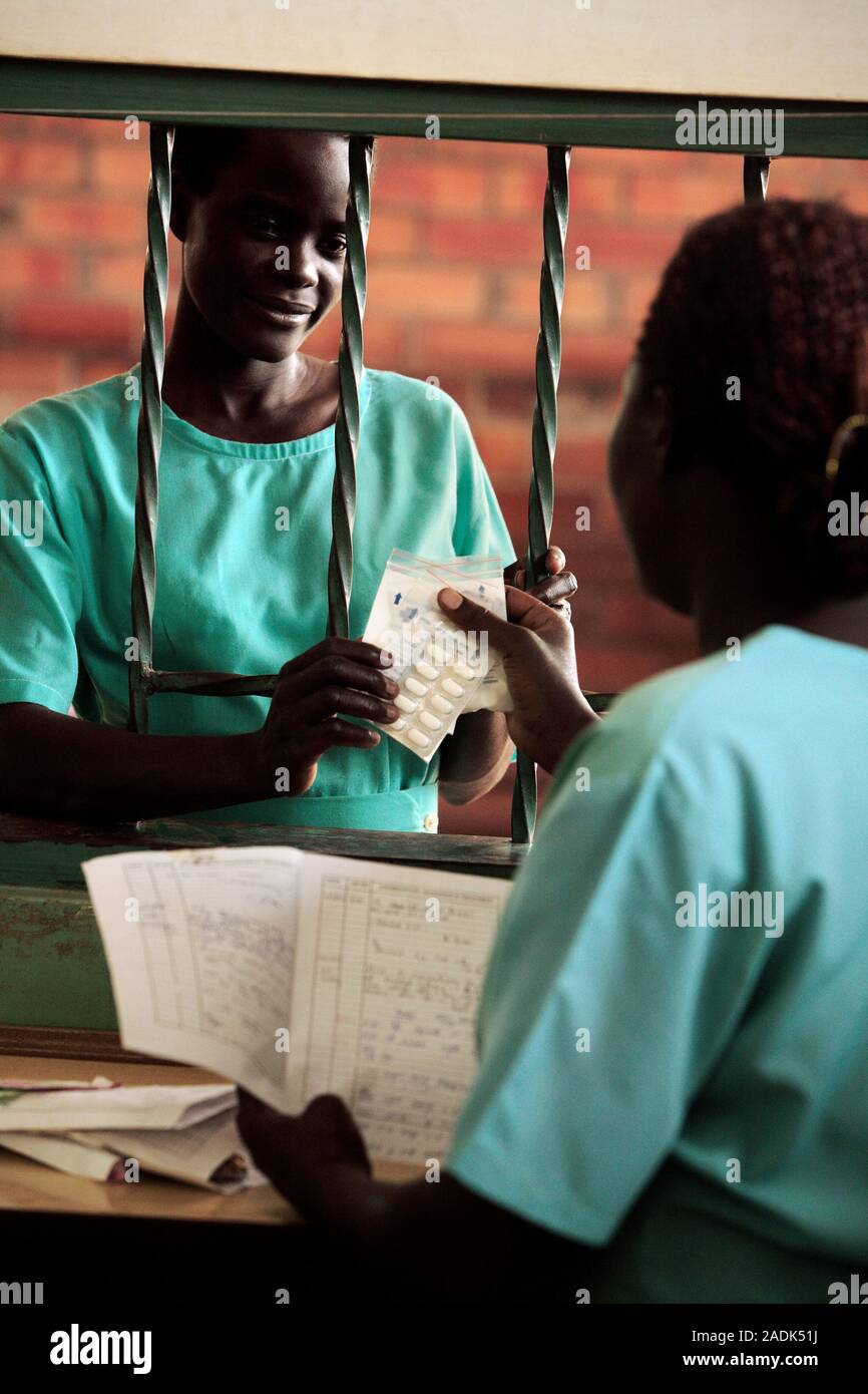 MODEL RELEASED. Dispensing medication. Pharmacist (right) giving ...