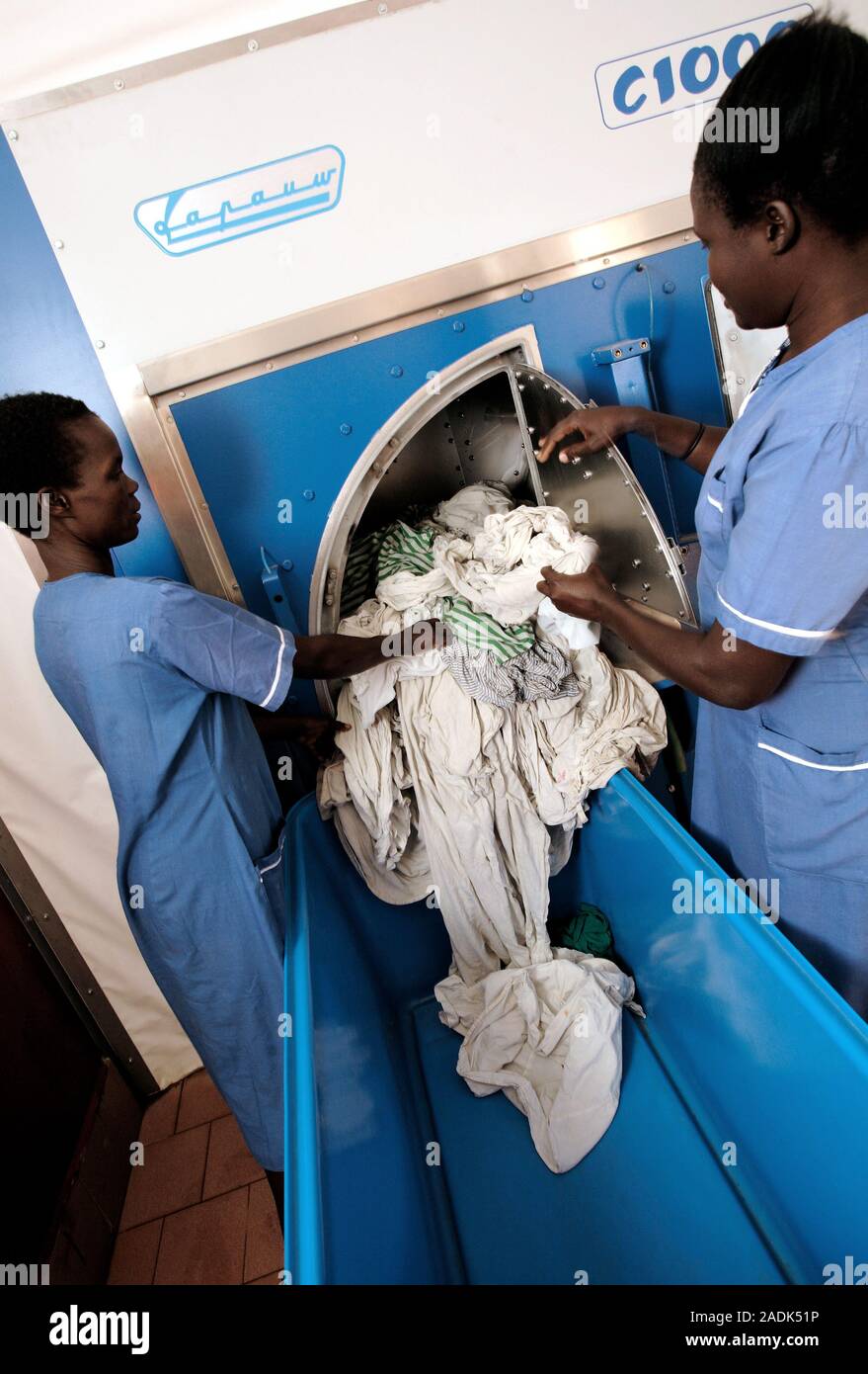 MODEL RELEASED. Hospital laundry. Hospital staff loading a washing ...
