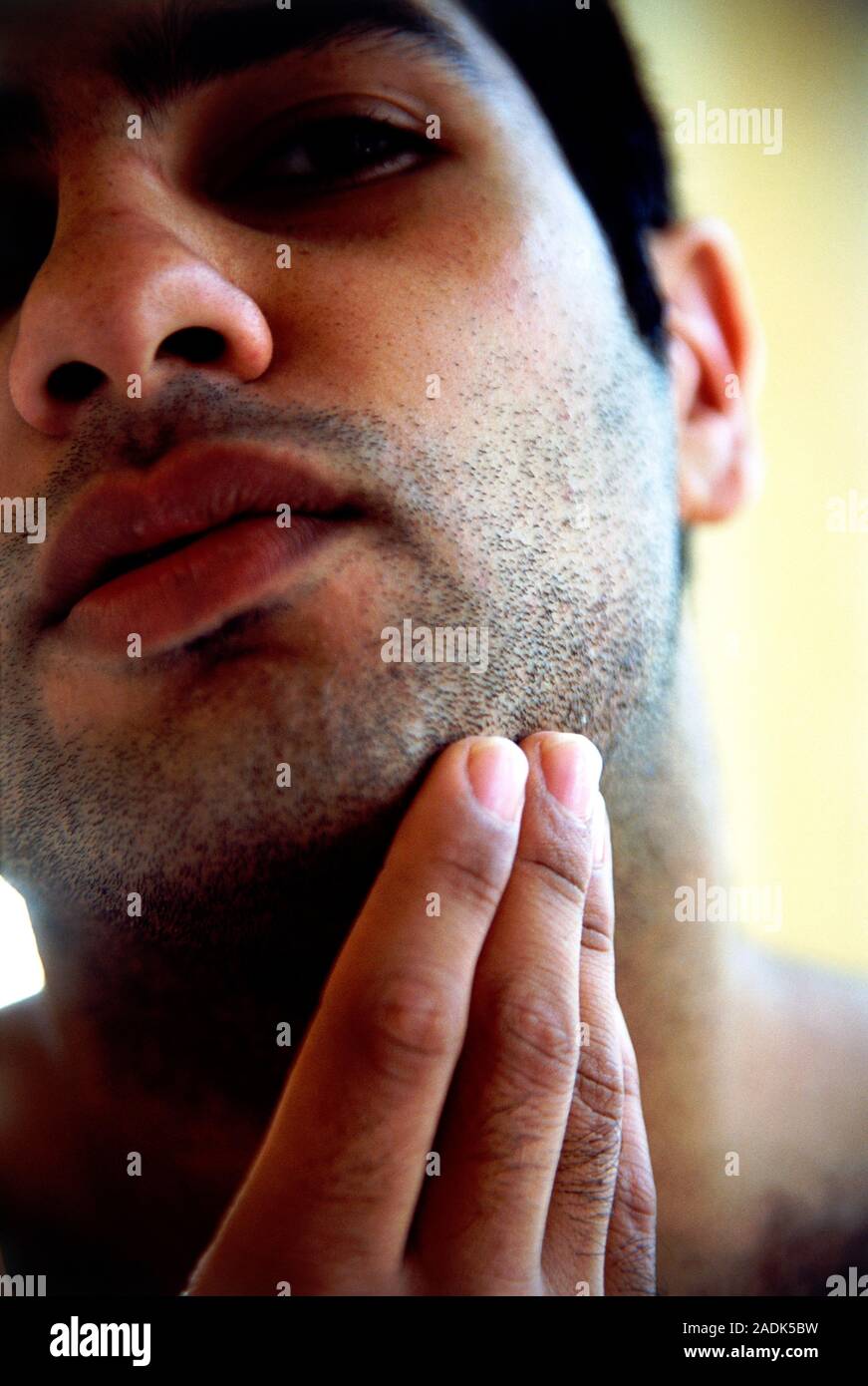 Man feeling stubble on his face before shaving Stock Photo - Alamy
