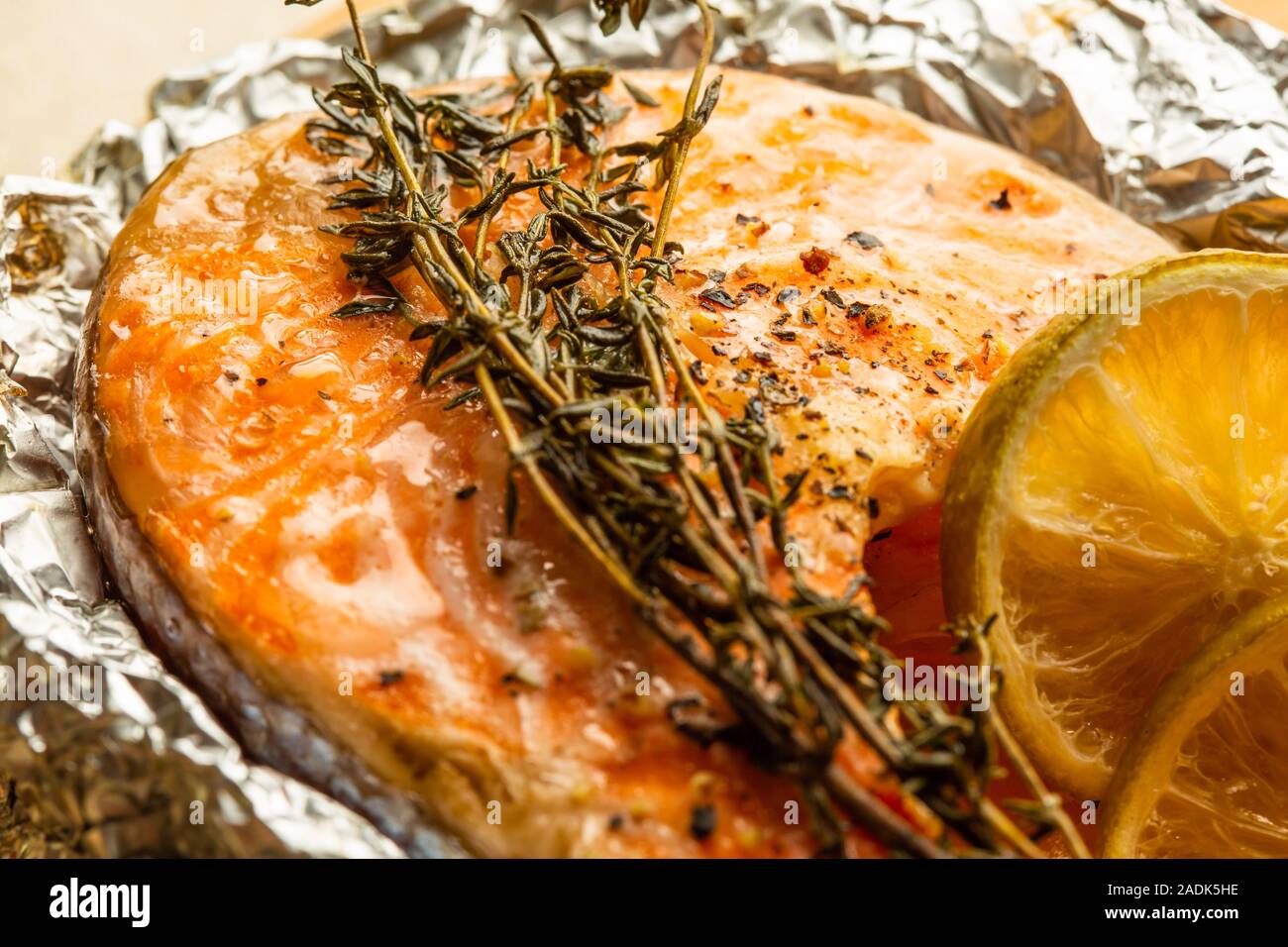 Close up of the branch of thyme on baked fish in foil with herbs Stock ...