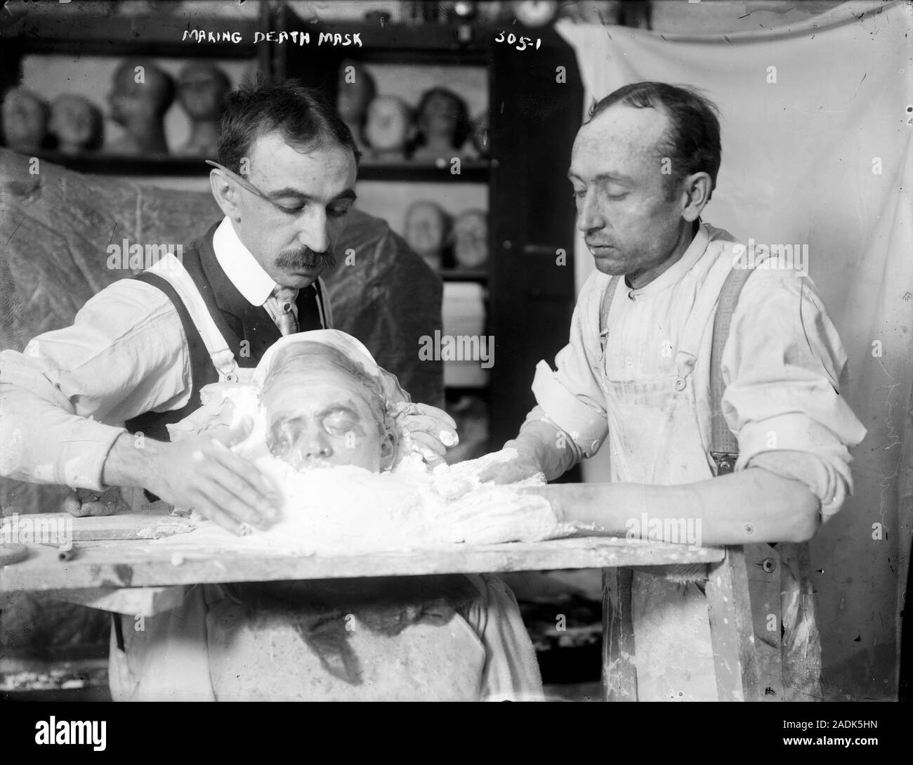 Death mask. Two men making a death mask of a dead woman. A death mask ...