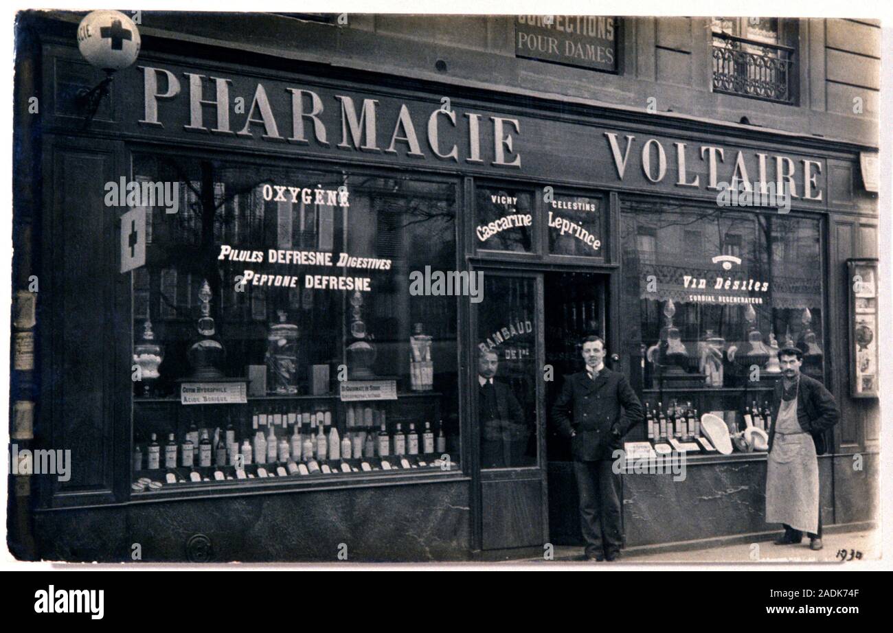 French pharmacy. Pharmacist and workers standing outside of the Pharmacie Voltaire on Boulevard ...