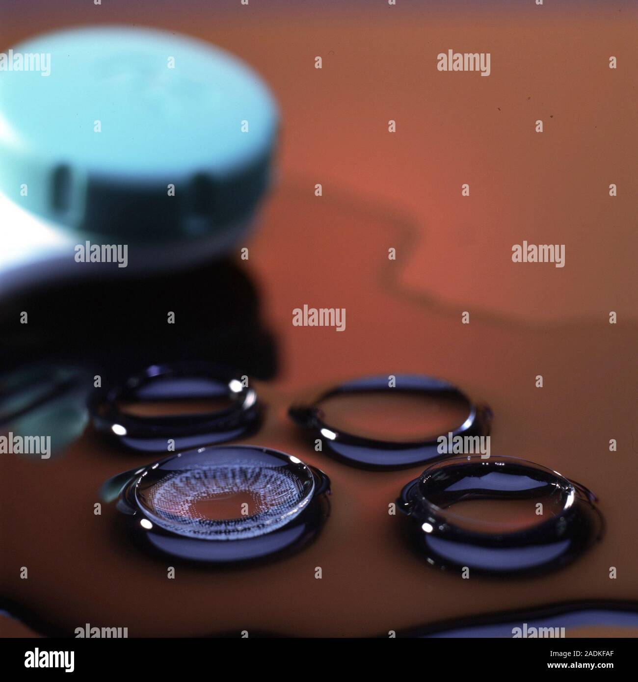 Contact lenses by a bottle. These lenses are placed over the cornea of ...