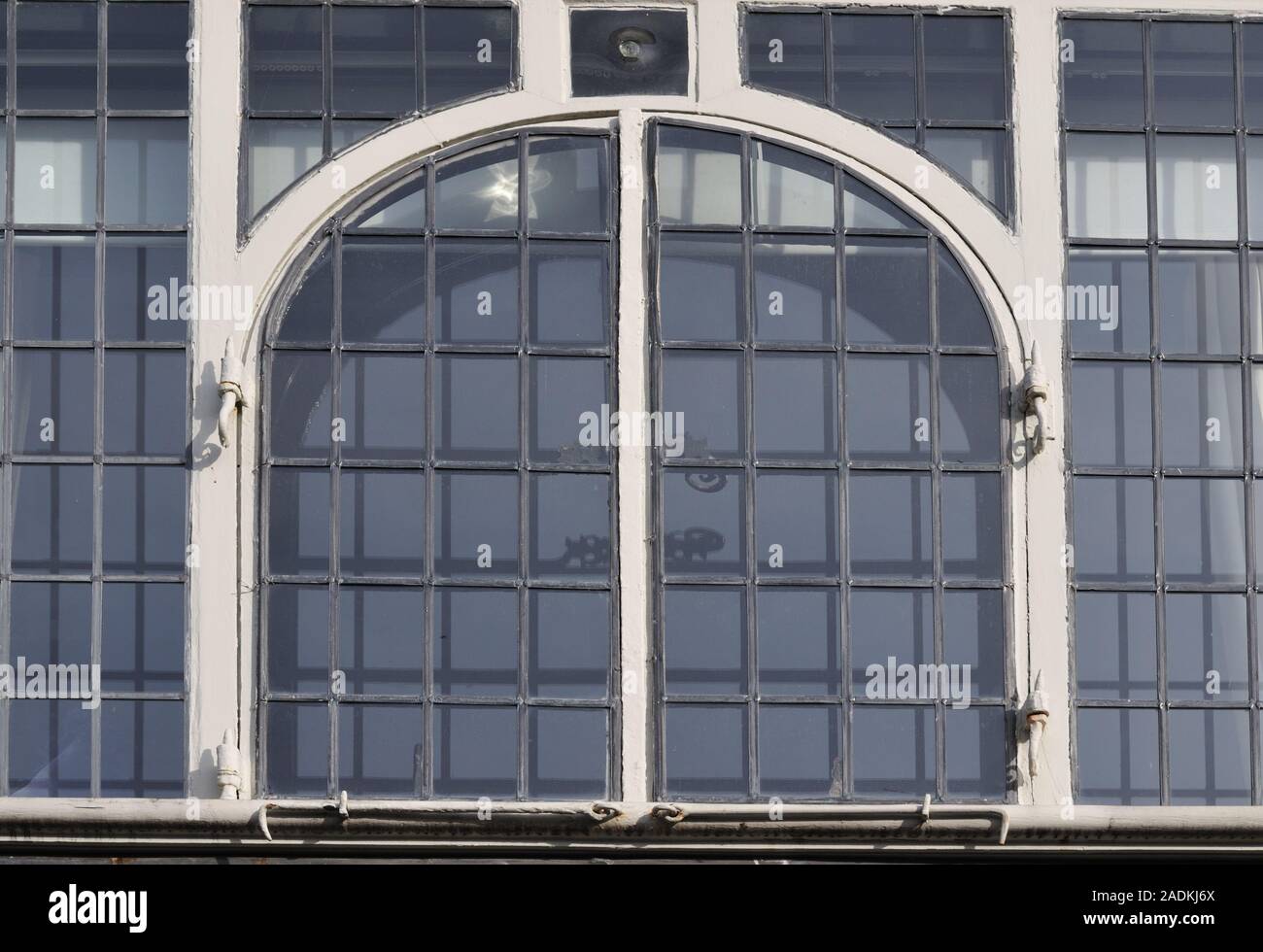 old arched window with white painted wooden frame and leaded glass in ...