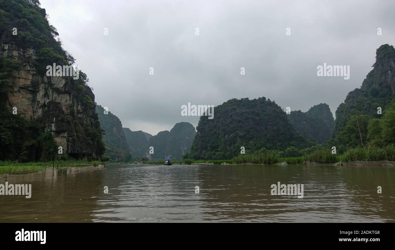 A view of the river and mountains of Tam Coc during a boat ride near ...