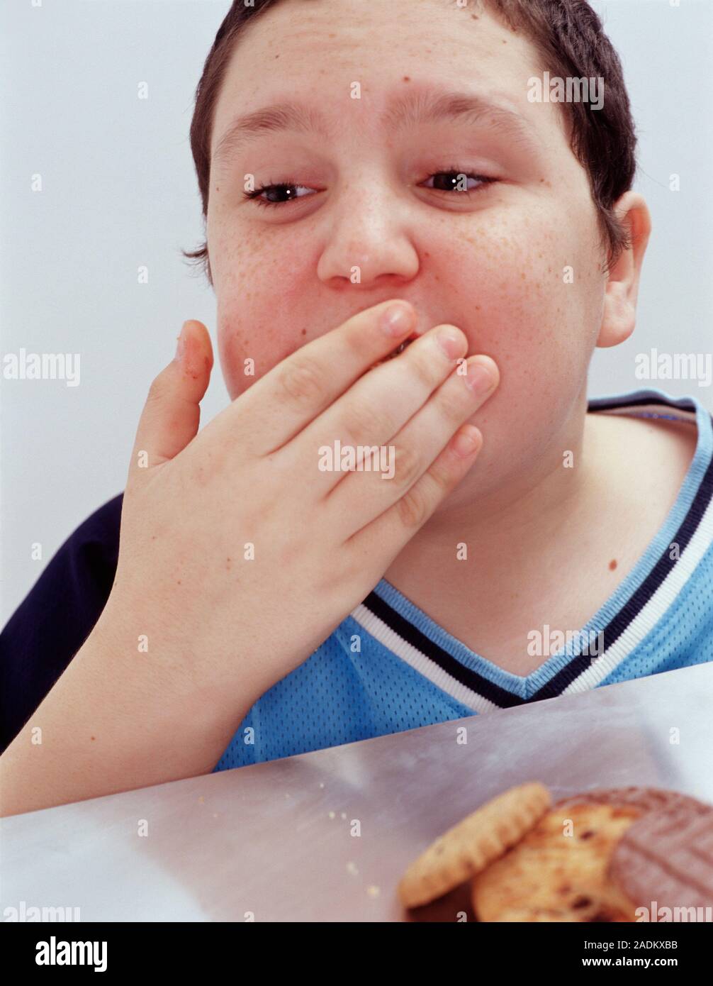 Eating biscuits. Boy with a mouthful of biscuits. These contain sugar ...
