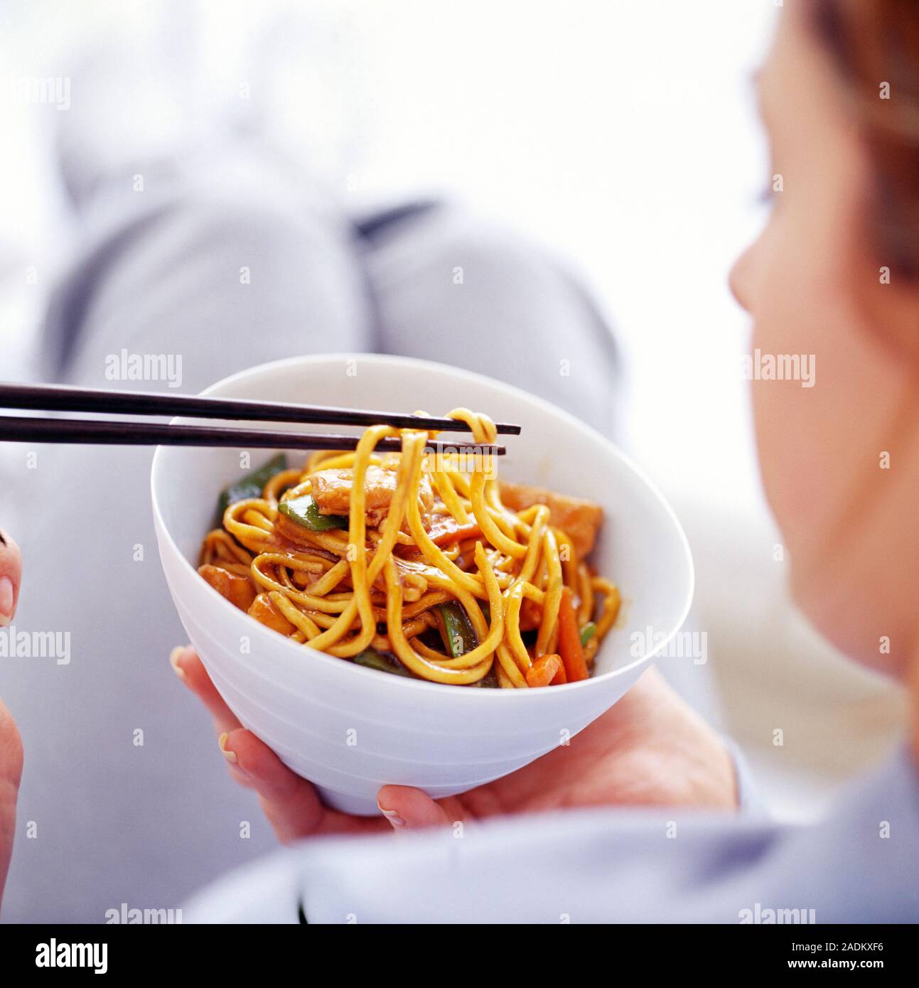Chinese meal. Woman using chopsticks to eat a Chinese meal Stock Photo ...
