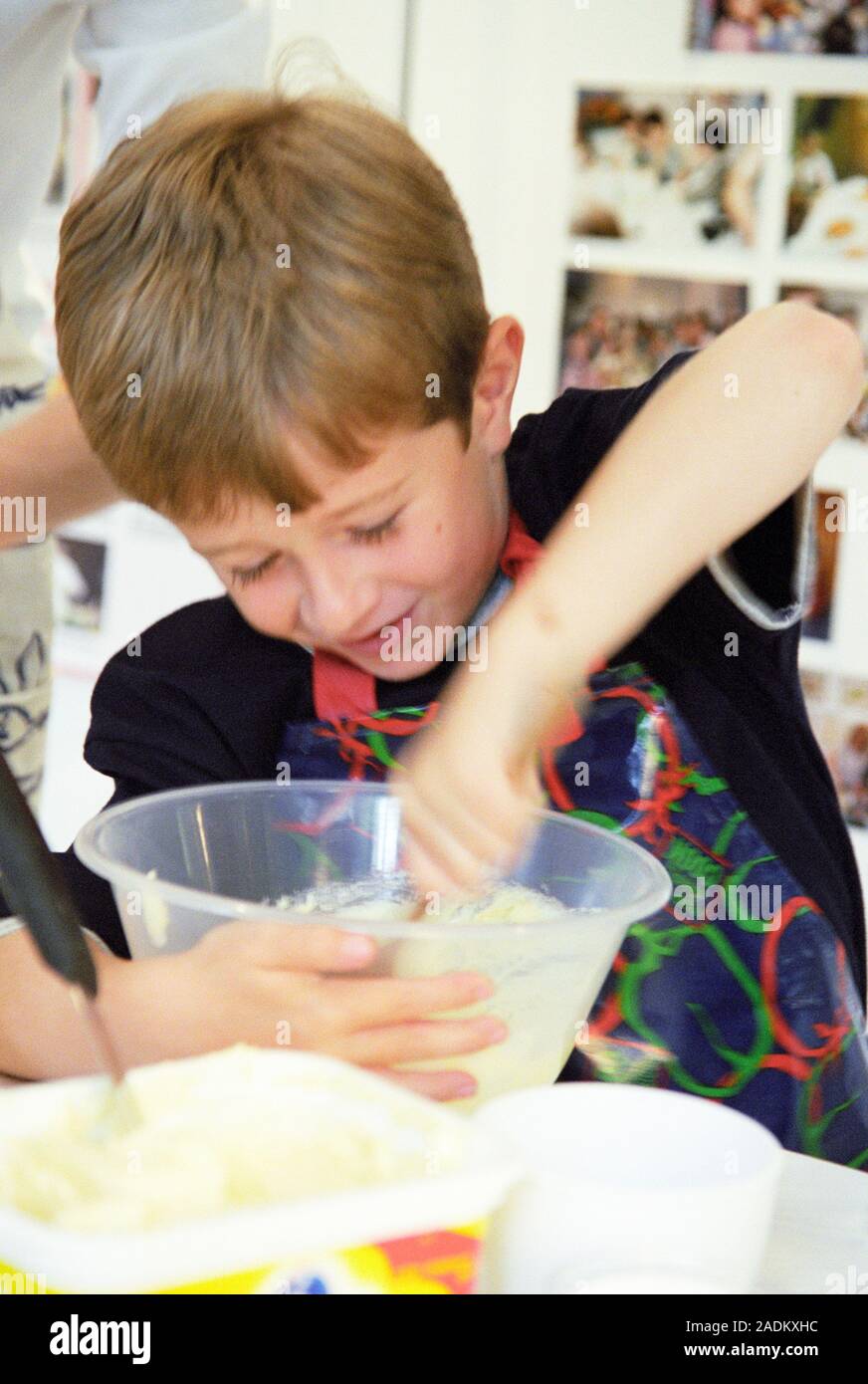 Making cakes. Image 3 of 8. 5- year-old boy mixing an egg into a bowl ...