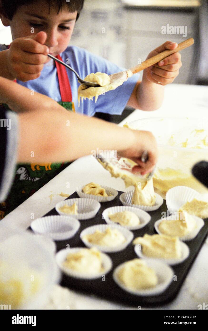 Making cakes. Image 4 of 8. Two 5-year-old boys dividing cake mixture ...
