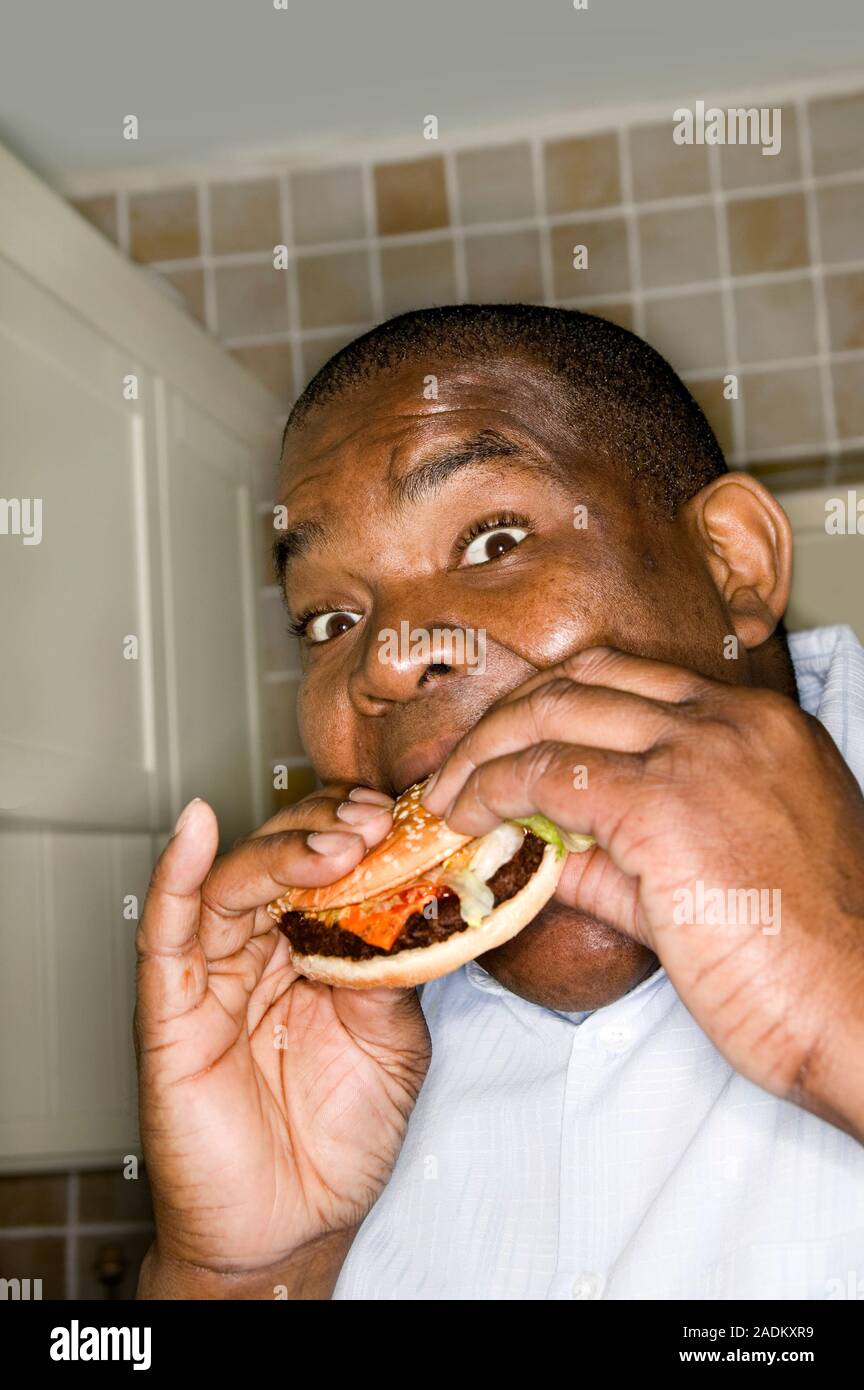 Man eating a burger in his house Stock Photo - Alamy