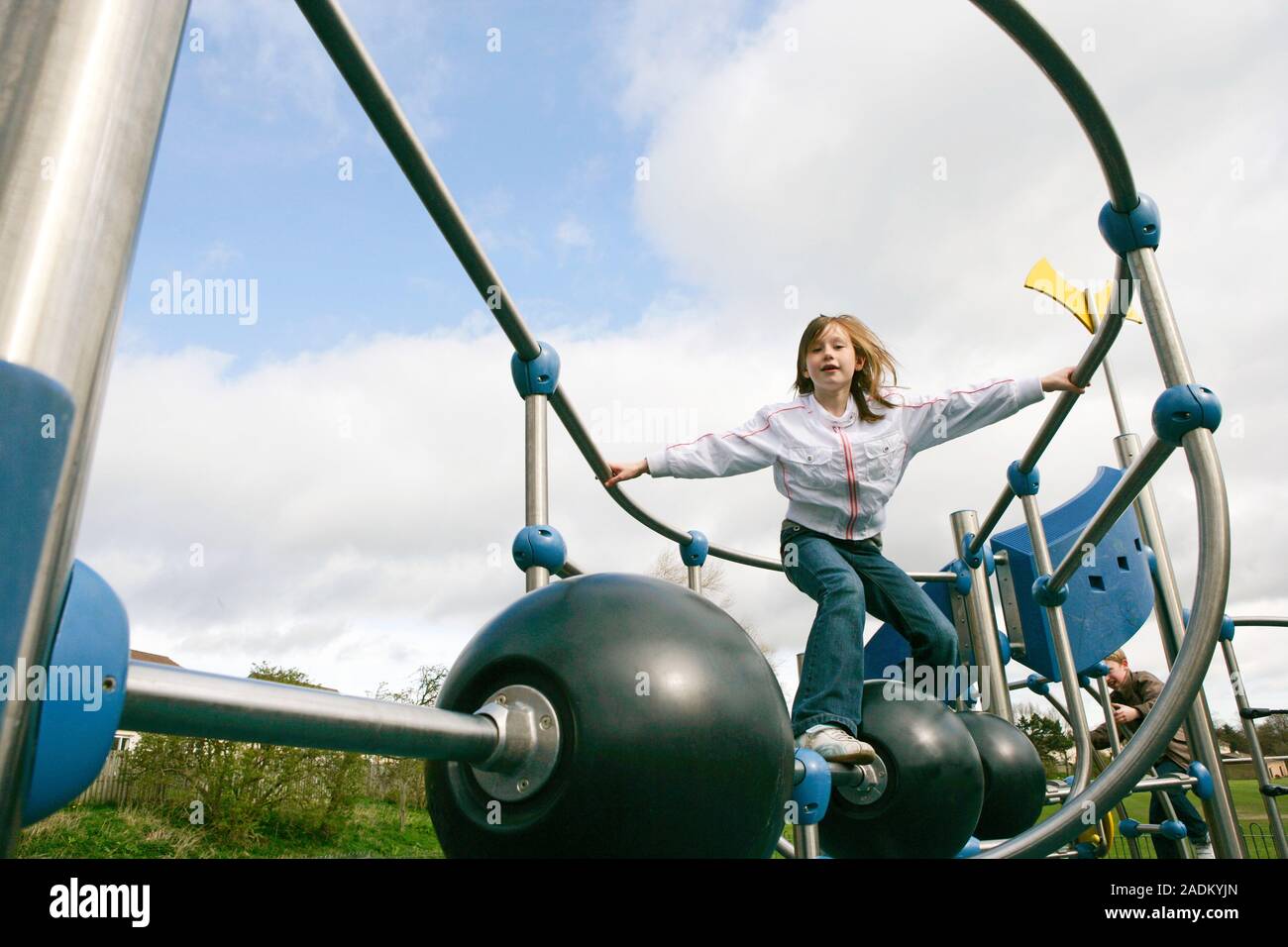 MODEL RELEASED. Girl playing on a climbing frame in a playground Stock ...