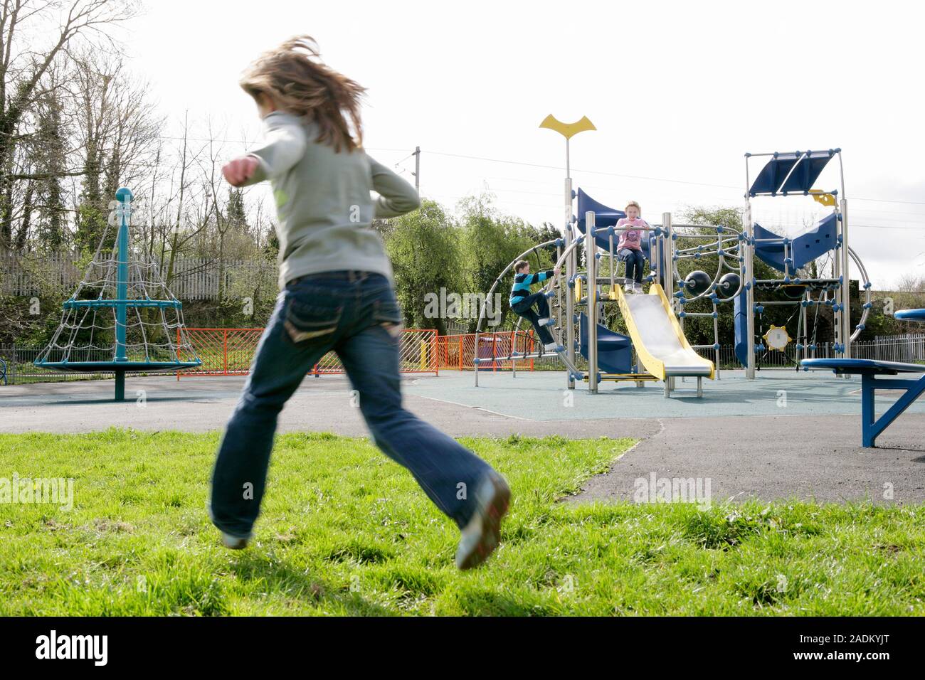 MODEL RELEASED. Girl running across a playground Stock Photo - Alamy