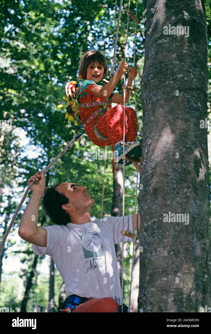 Acrobranching. Instructor teaching a young girl to acrobranch in the ...