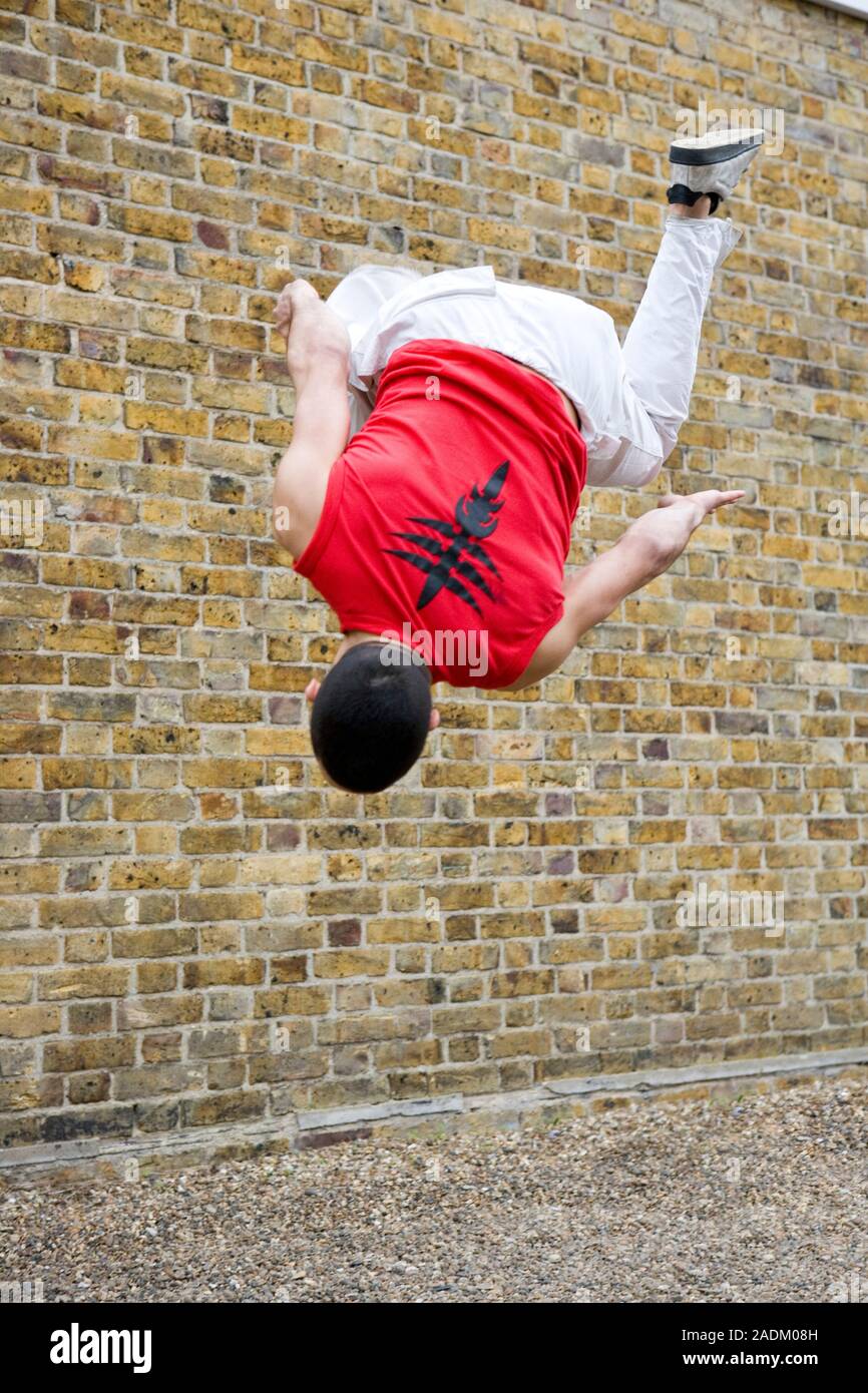 MODEL RELEASED. Man jumping in mid-air. Man performing a back-flip ...