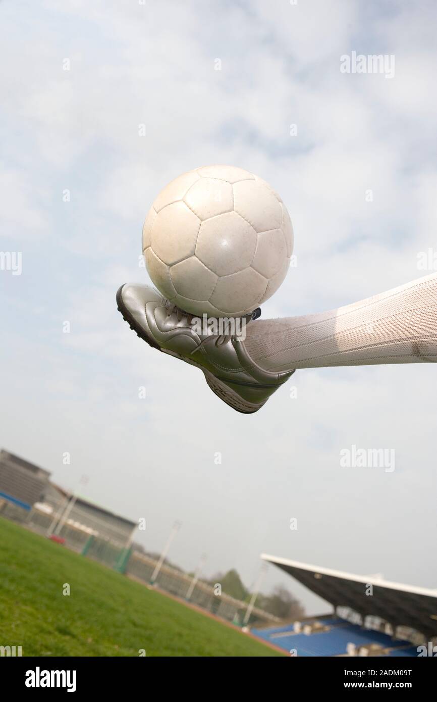 MODEL RELEASED. Football balancing on a footballer's boot Stock Photo ...