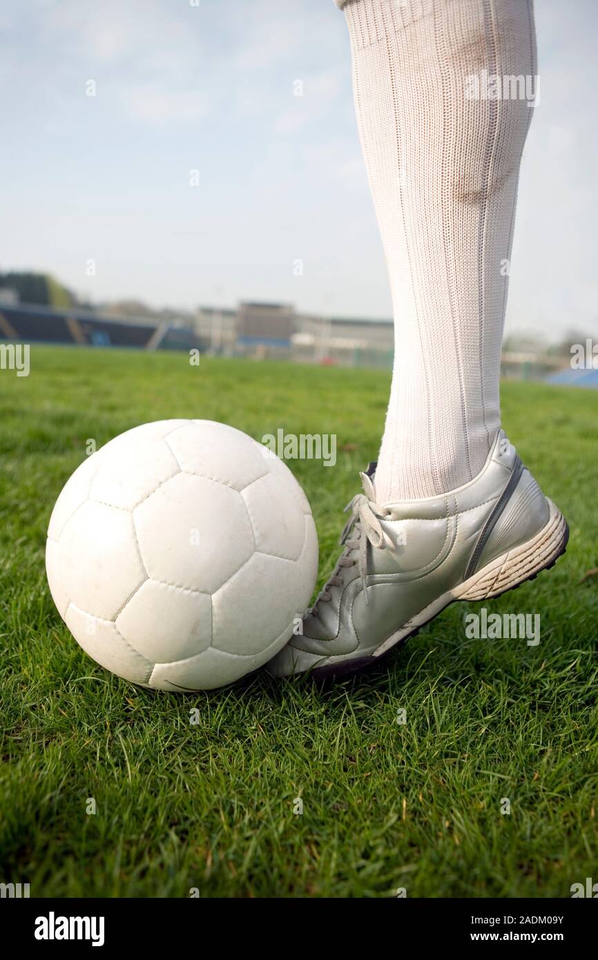 MODEL RELEASED. Footballer making contact with a football Stock Photo ...