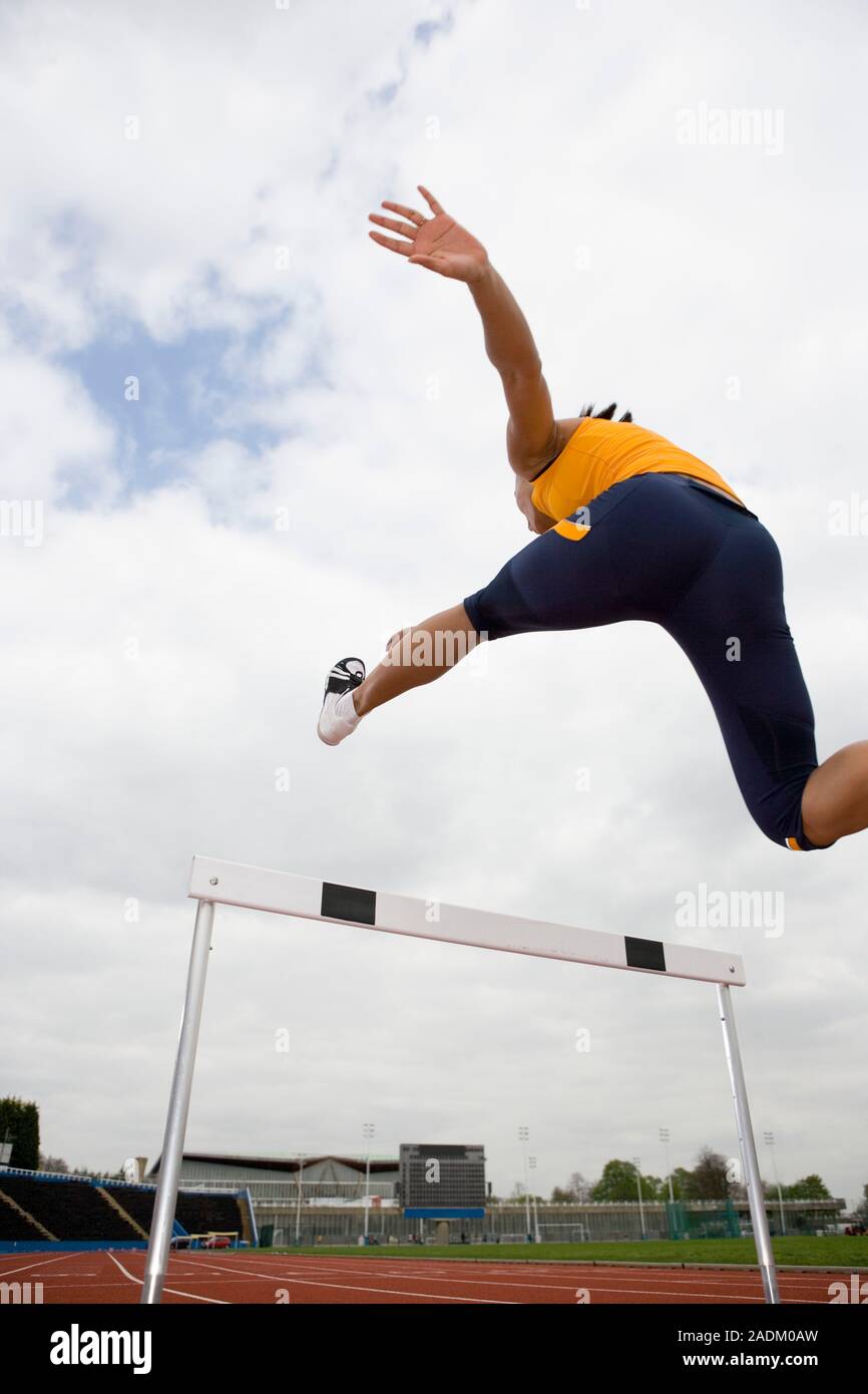 MODEL RELEASED. Athlete clearing a hurdle Stock Photo - Alamy
