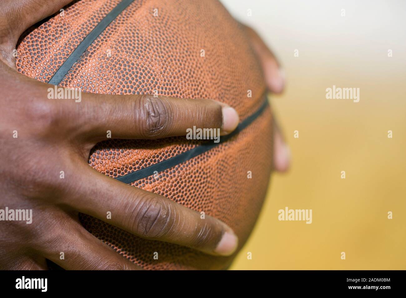 MODEL RELEASED. Basketball player holding a basketball. The basketball ...