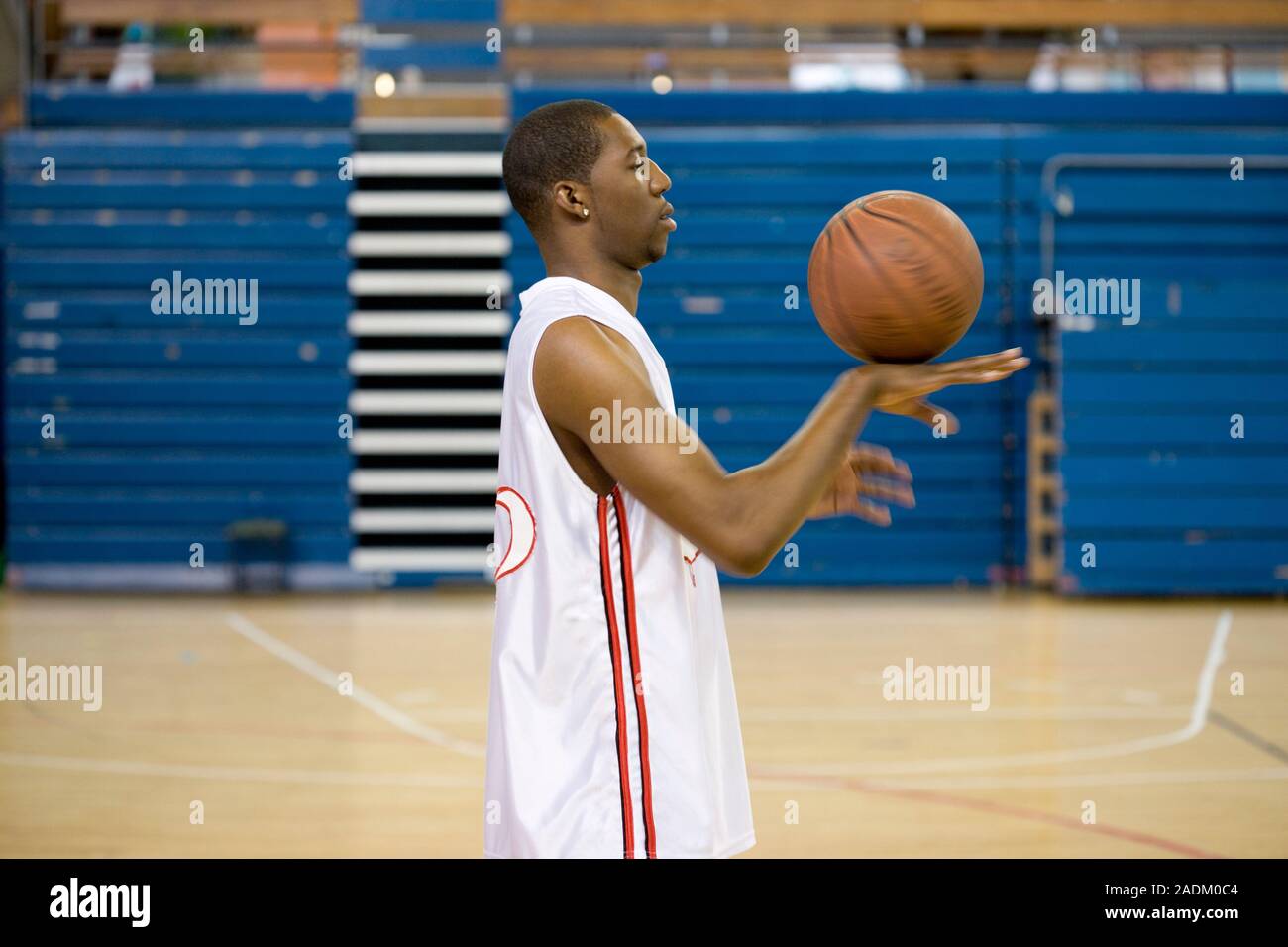 MODEL RELEASED. Basketball player balancing a basketball on his hand ...