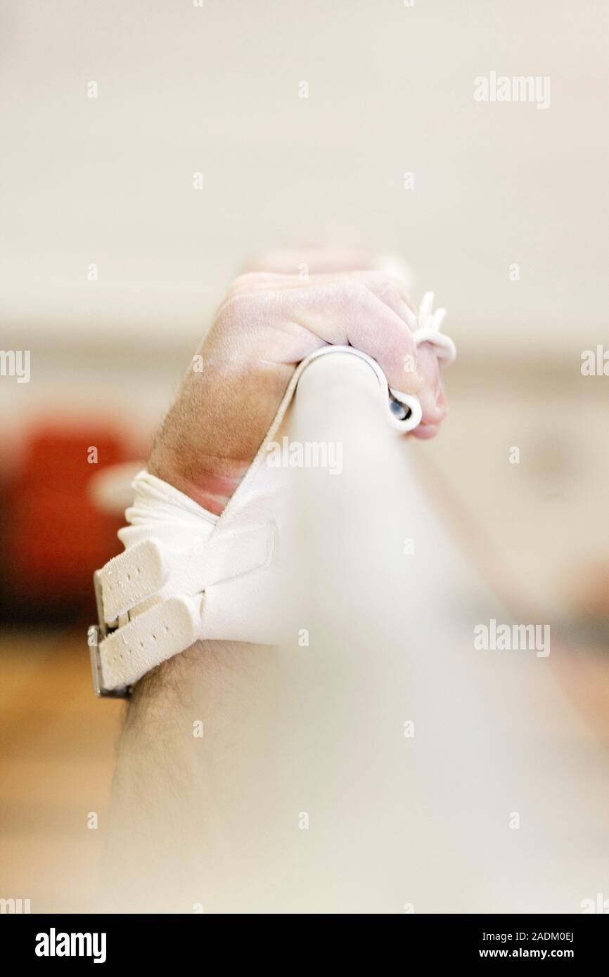 MODEL RELEASED. Gymnast's hands gripping a bar. The hands are chalked ...