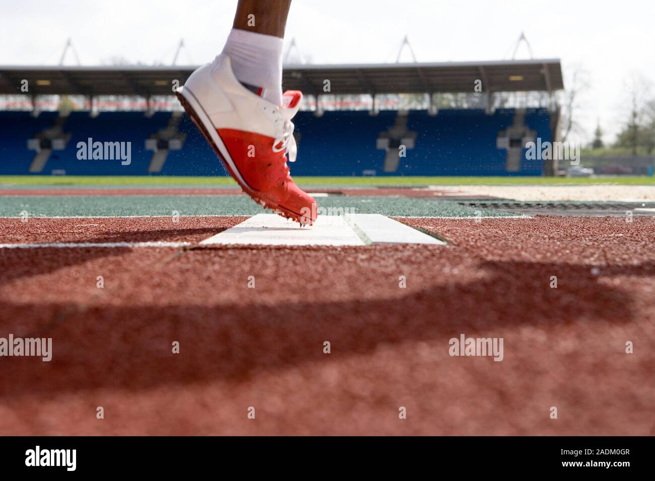 MODEL RELEASED. Athlete's foot lifting off the take-off point while ...
