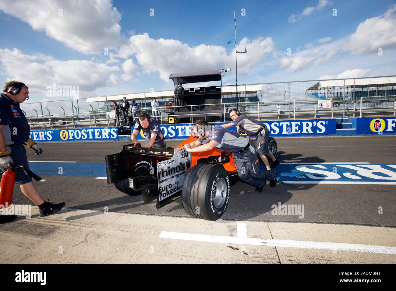 Formula One racing car testing. Pit crew pushing a racing car back into ...