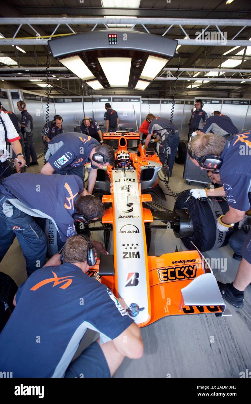 MODEL RELEASED. Formula One racing. Pit crew removing tyre warmers and ...