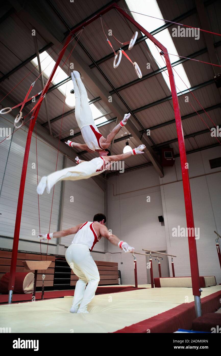 MODEL RELEASED. Gymnast performing on rings. Composite high-speed ...