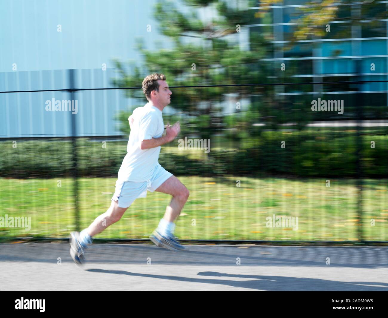 Man running along an urban footpath Stock Photo - Alamy