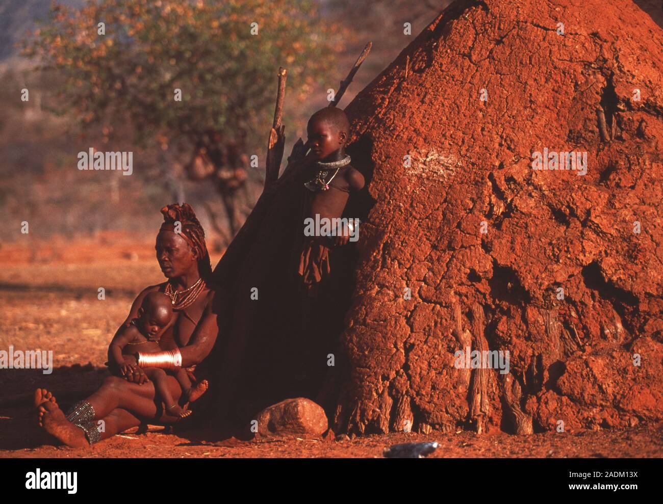 Himba people. Mother with her children in a Himba homestead. The Himba ...