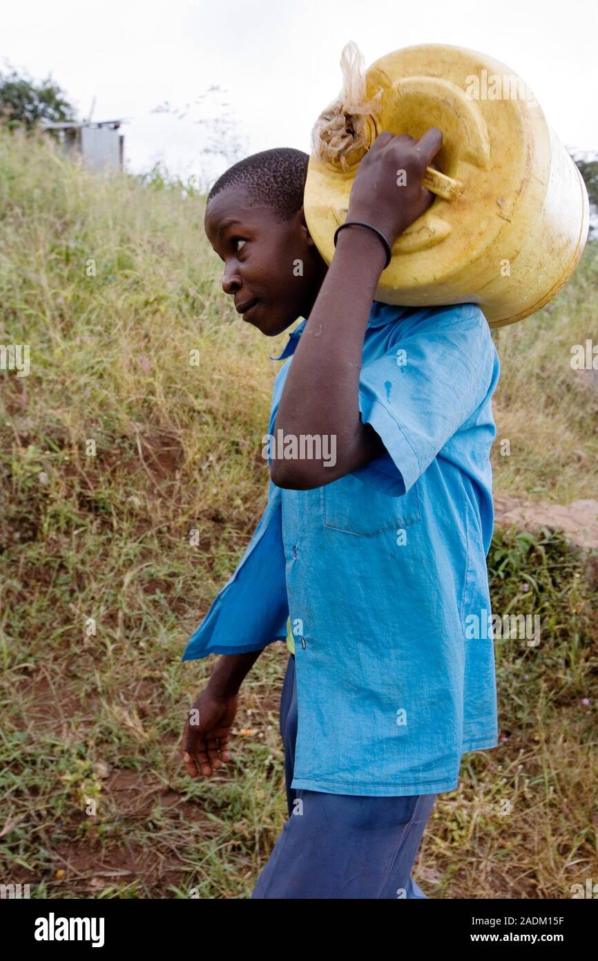 Carrying water. Boy carrying a water tank on his shoulder. Photographed ...