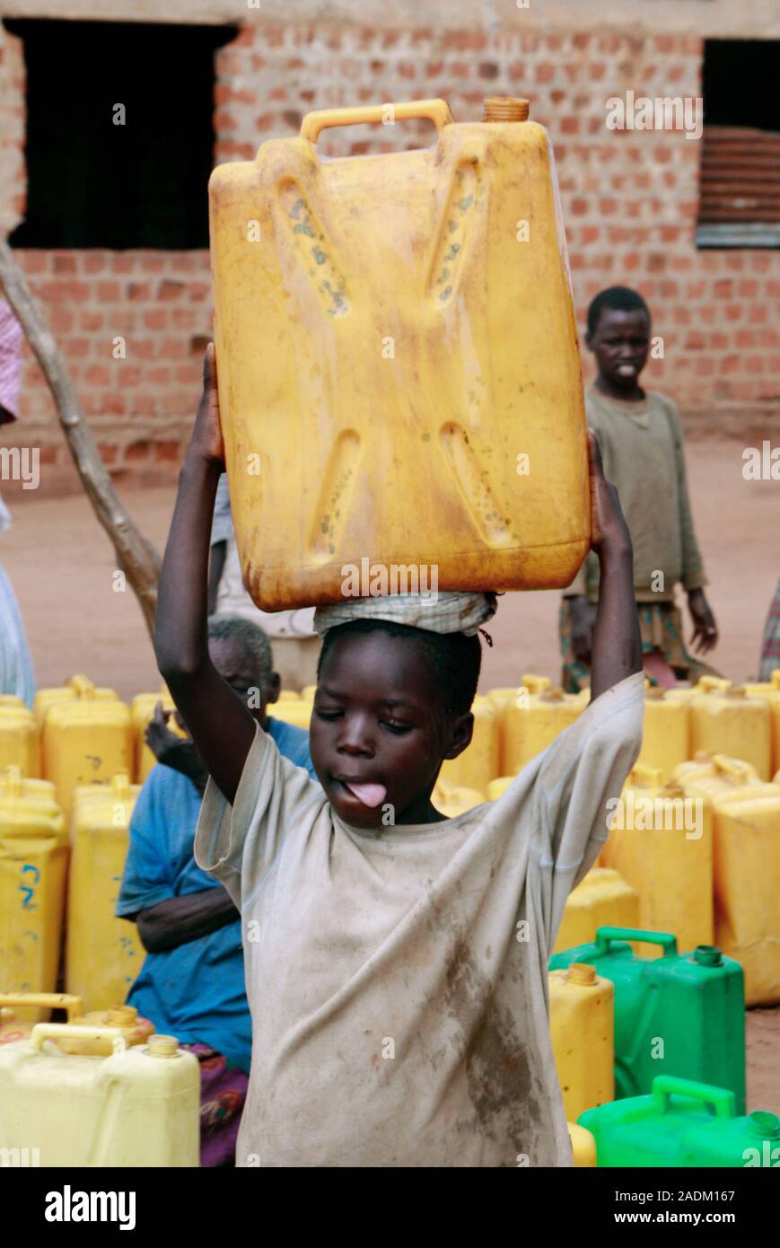 Carrying water. Child carrying a water can back home on his head. In ...