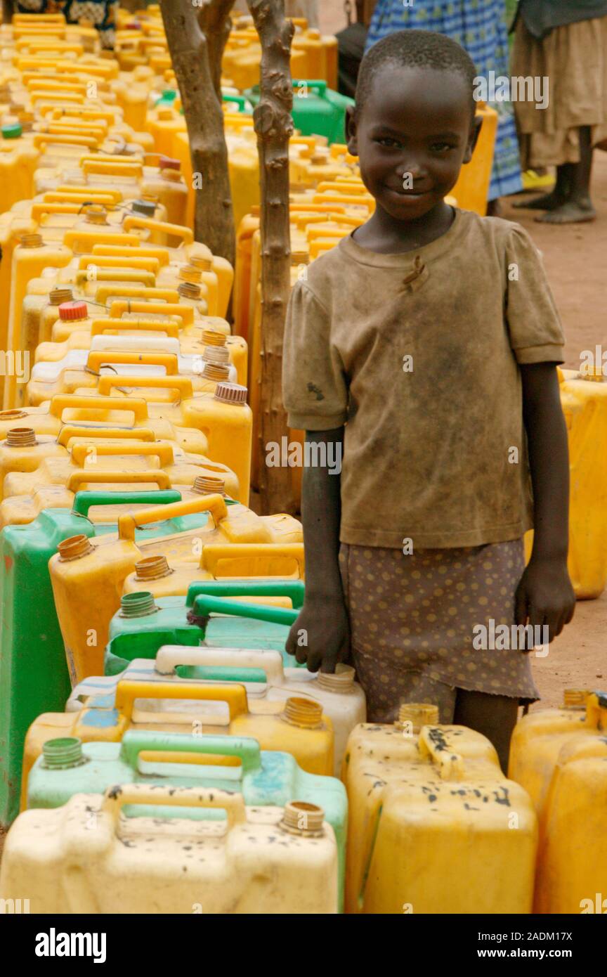 Child collecting water. Child standing beside a long row of plastic ...
