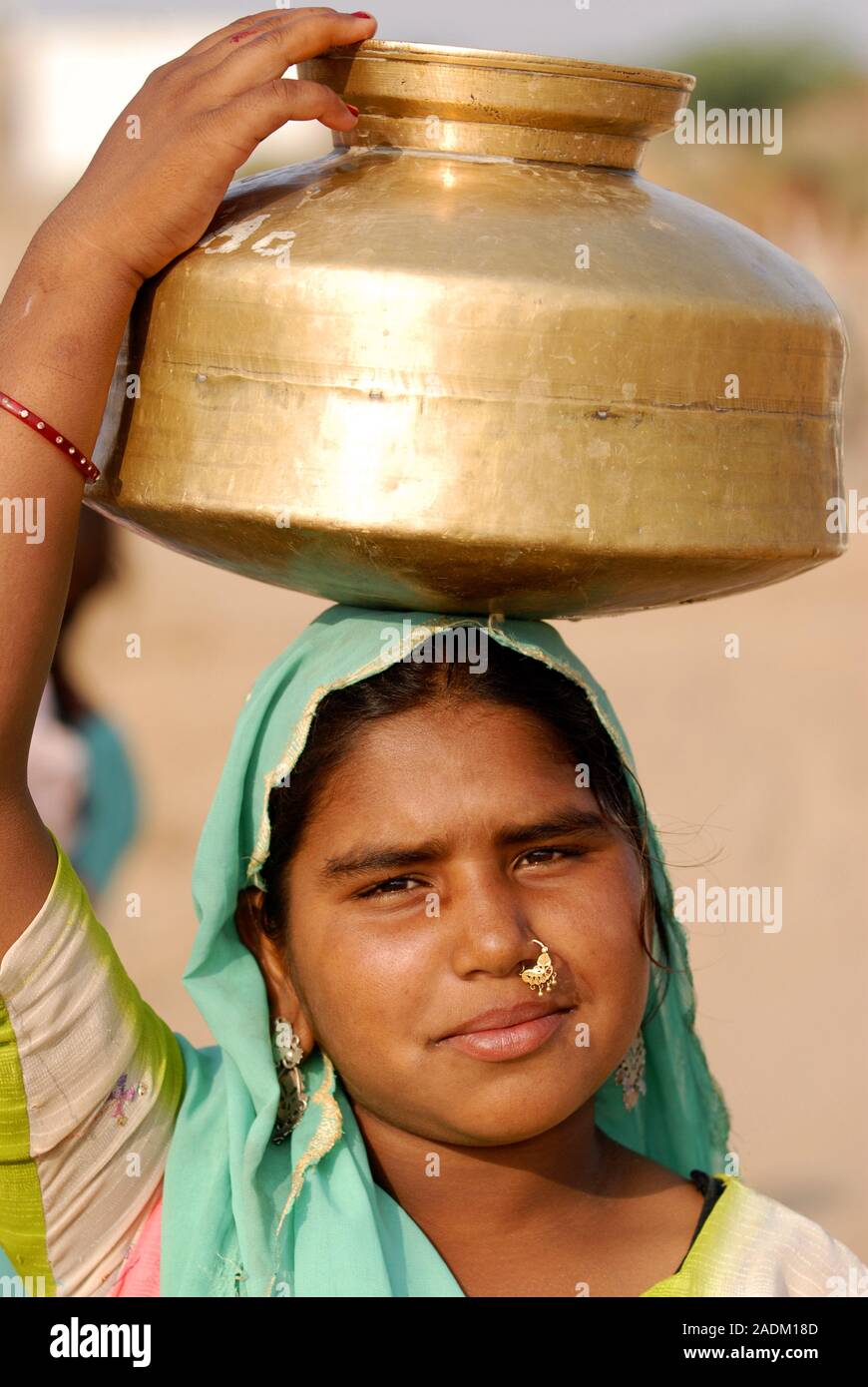 Girl carrying water in a copper pot on her head. Photographed in ...