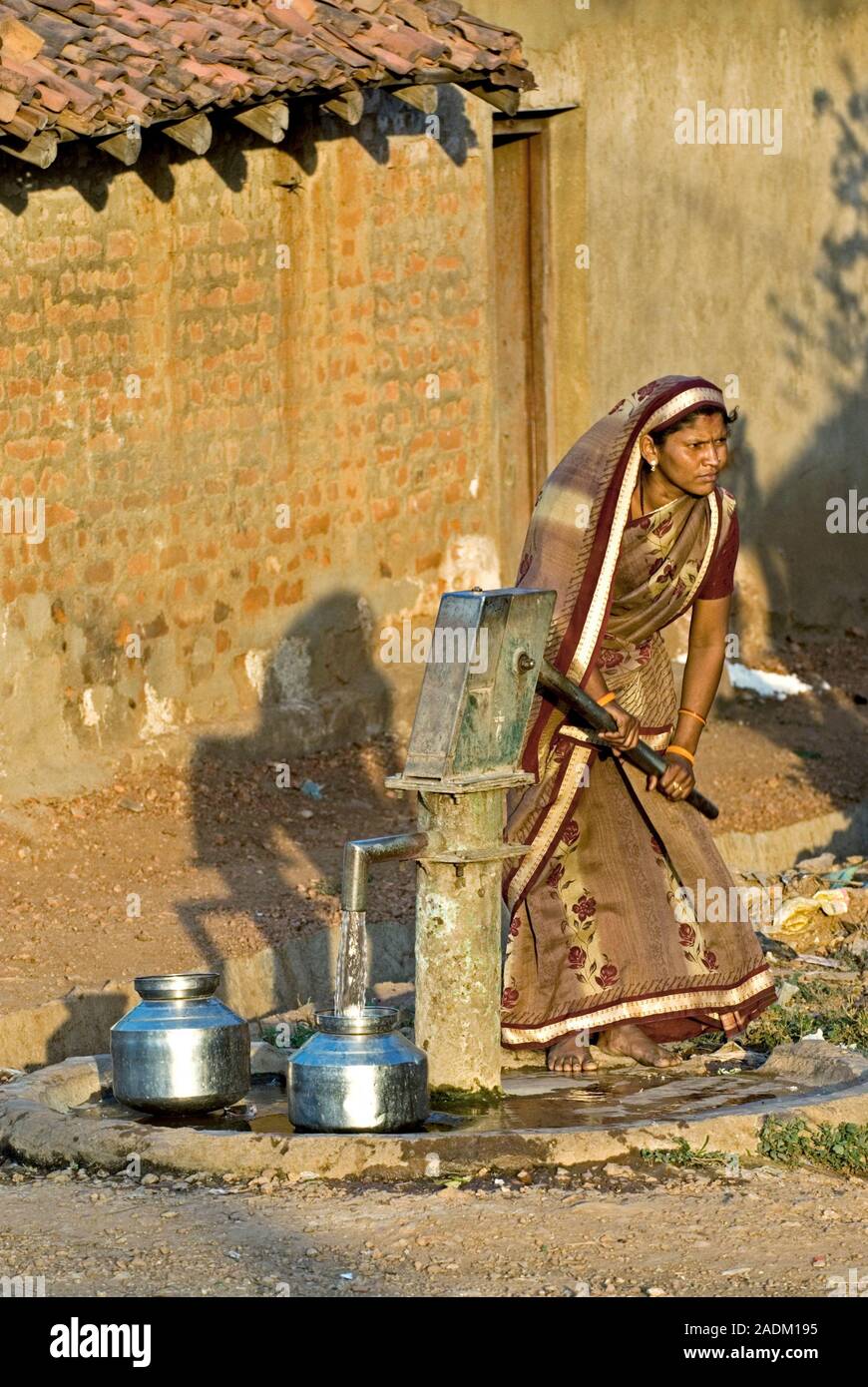 Water pump. Woman pumping clean, fresh water from a water pump in India ...