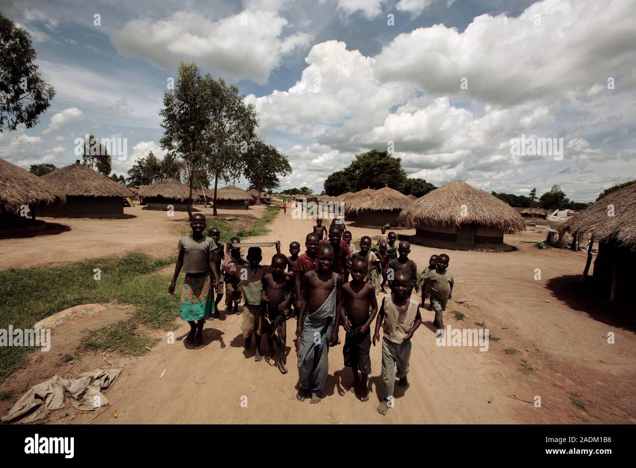 MODEL RELEASED. Children walking along a road through a village ...