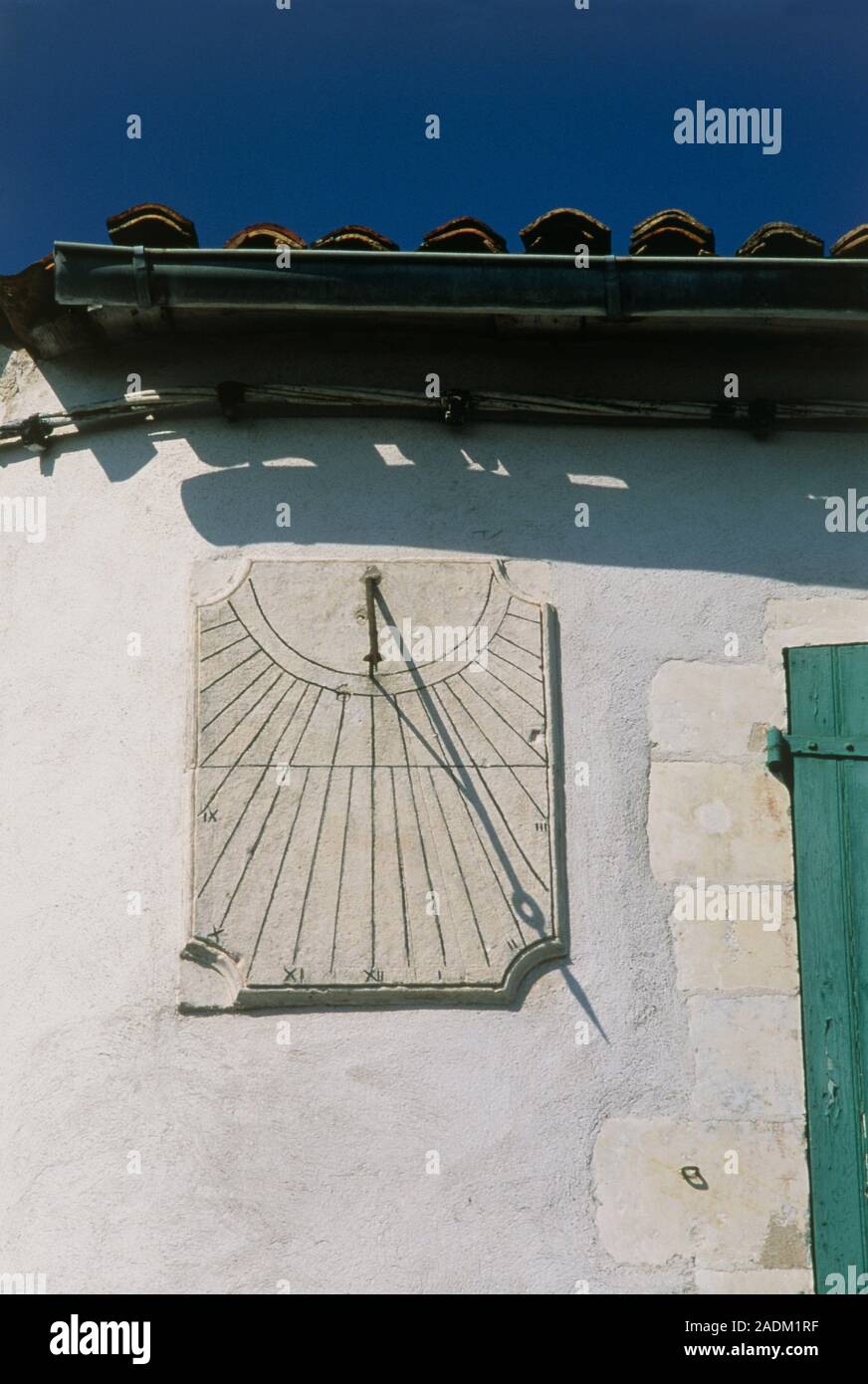 Sundial. Stone sundial attached to the wall of a building. The sundial ...